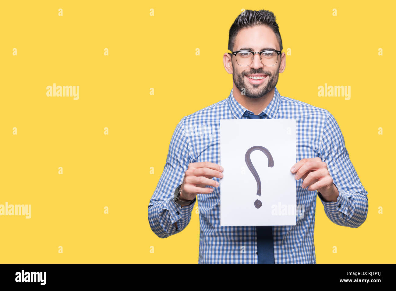 Handsome young business man holding paper with question mark over ...