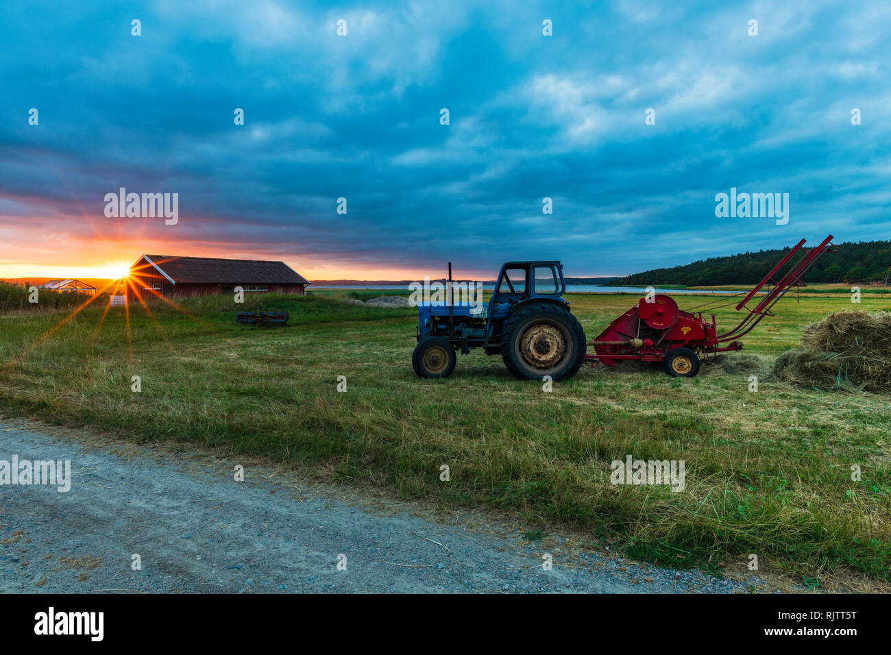 Dramatic sky above farmhouse and tractor in field, Halland, Sweden ...