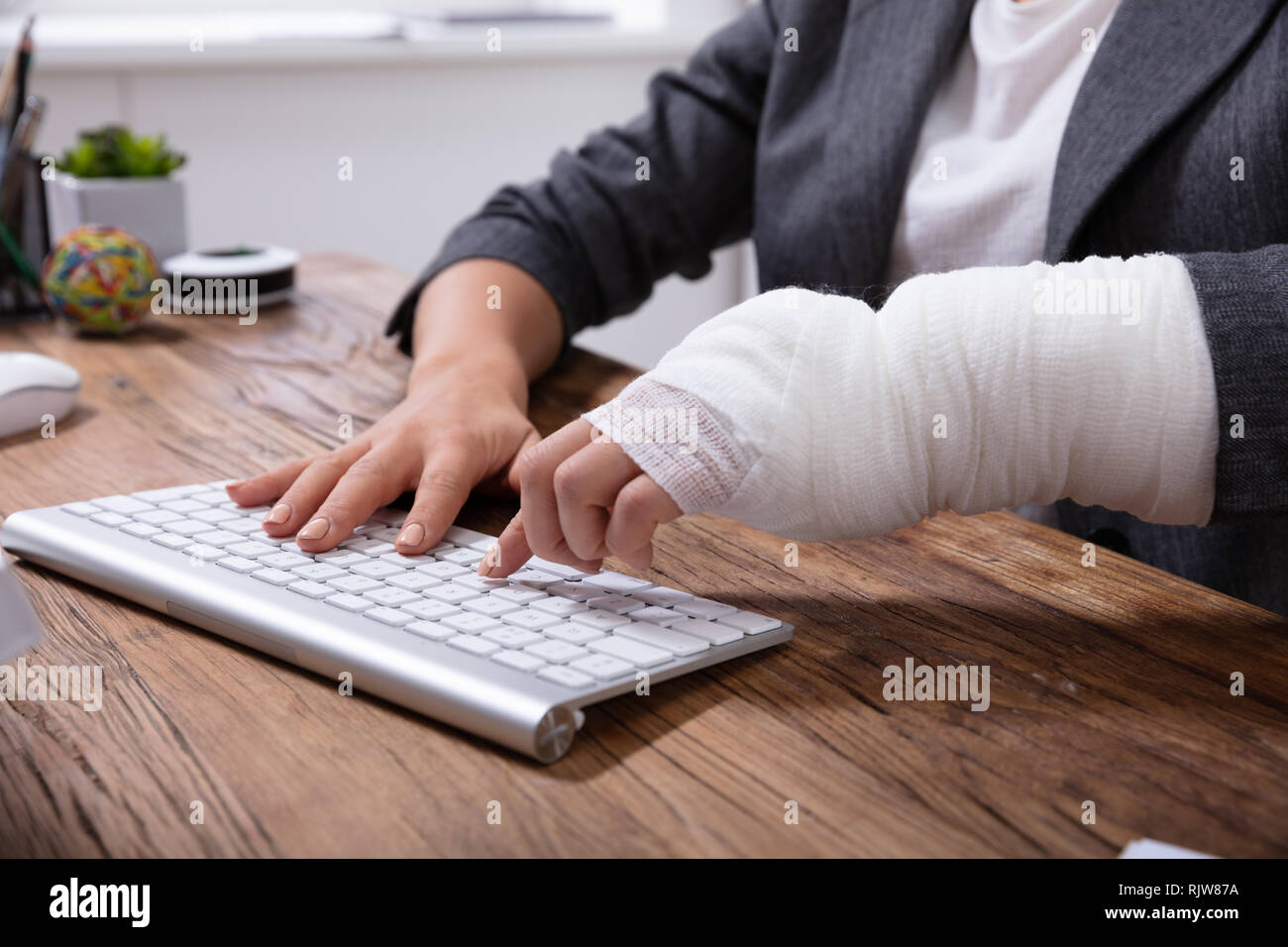Close-up Of A Businesswoman With Bandage Hand Using Computer At ...