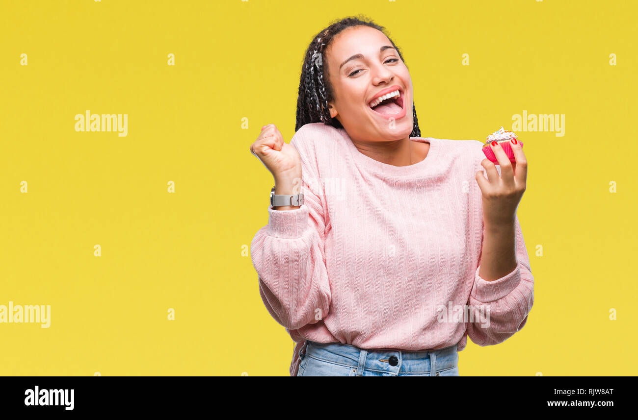 Young african american girl eating cupcake over isolated background ...