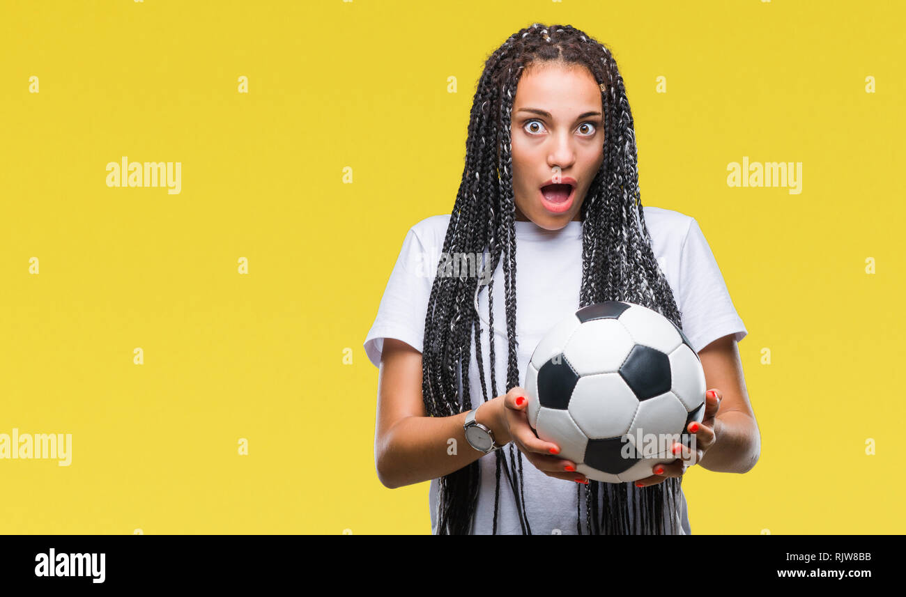 Young braided hair african american girl holding soccer ball over ...