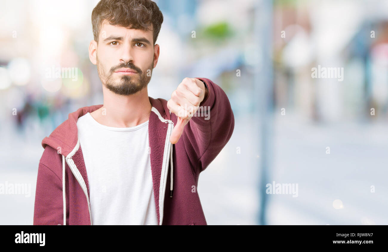Young handsome man over isolated background looking unhappy and angry ...