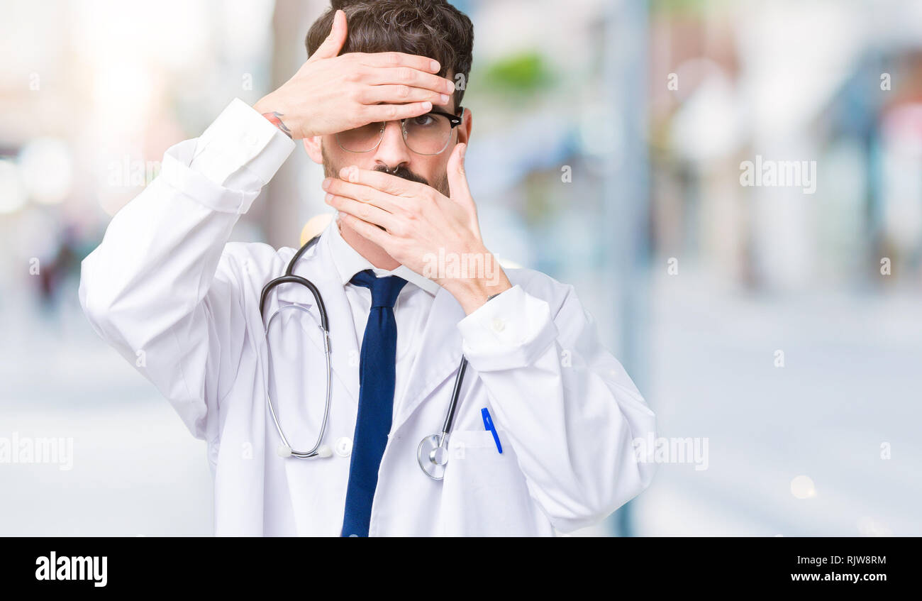 Young doctor man wearing hospital coat over isolated background ...