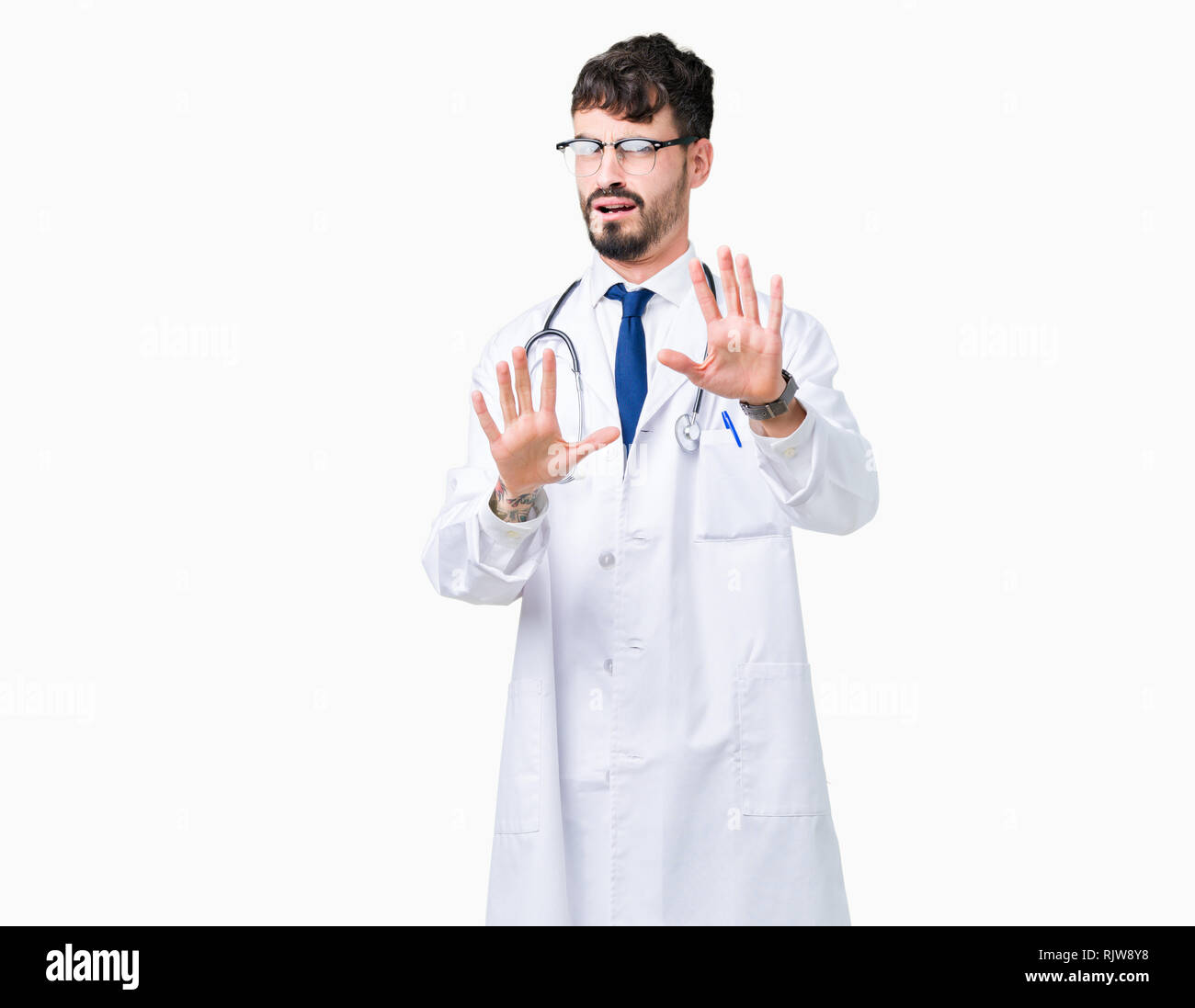 Young doctor man wearing hospital coat over isolated background afraid ...