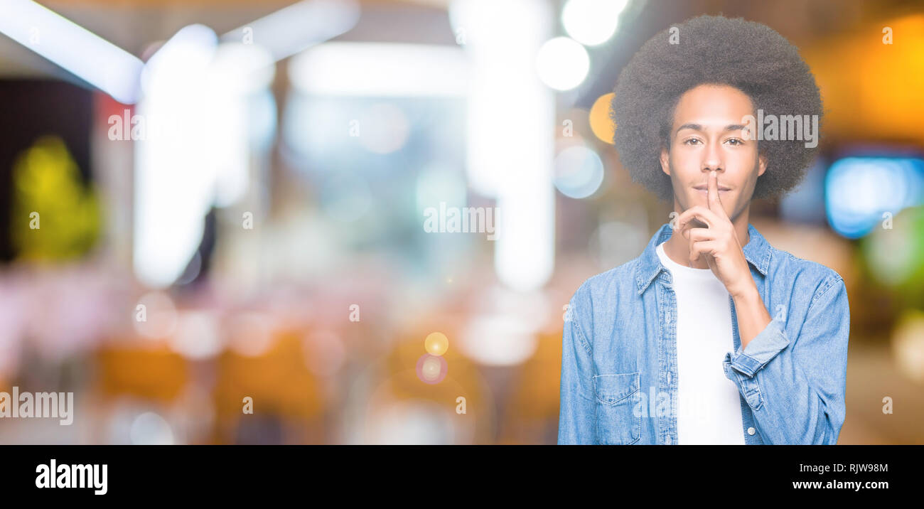 Young african american man with afro hair asking to be quiet with ...