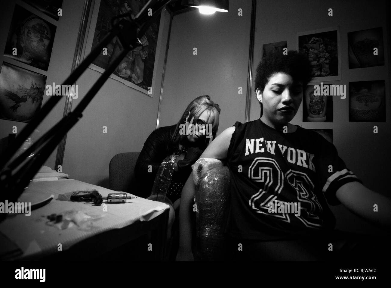 Tattoo artist tattooing into the skin of a person in a tattoo festival ...