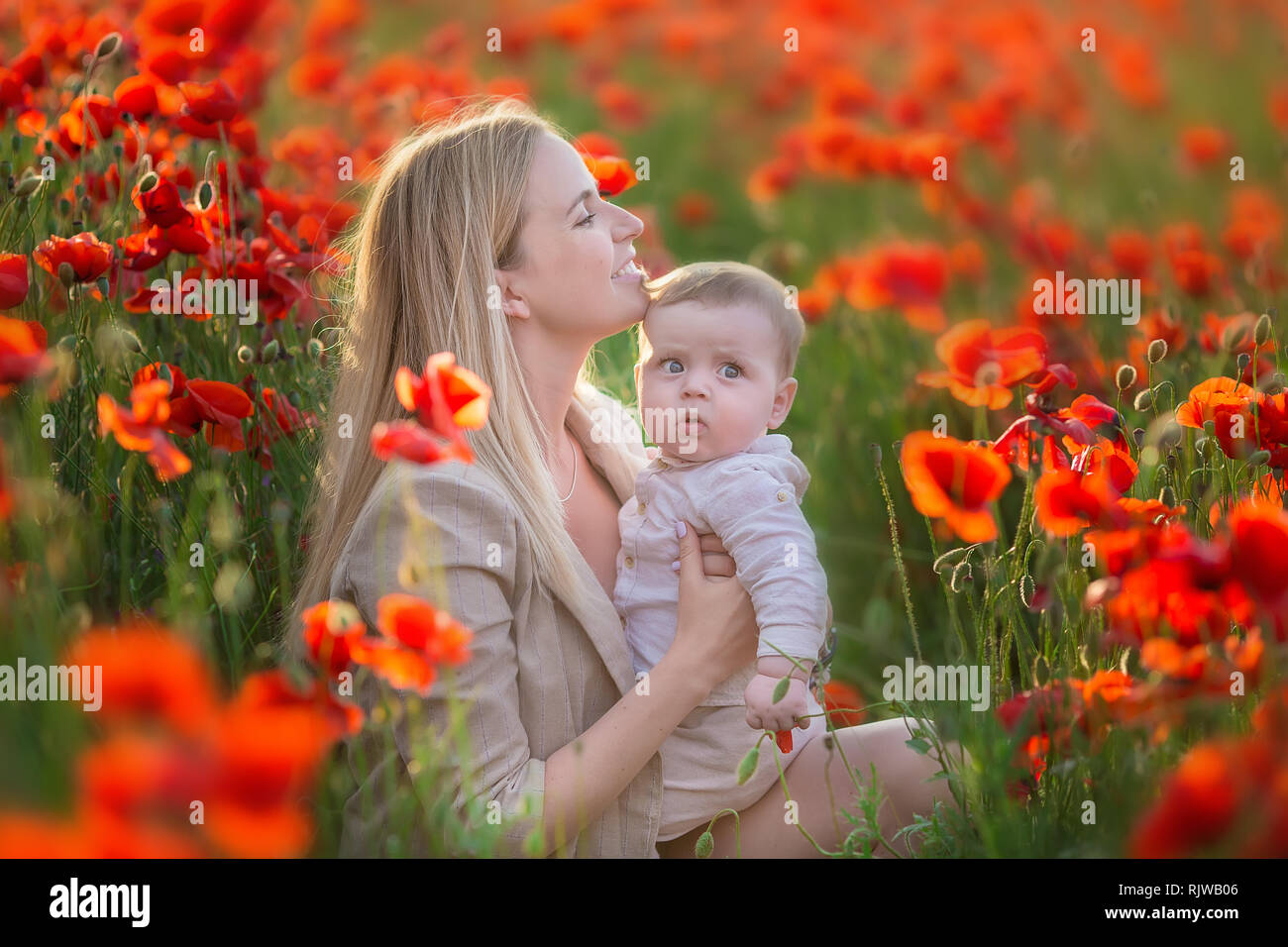 Happy motherhood. Mom and son daughter are playing in the field of ...