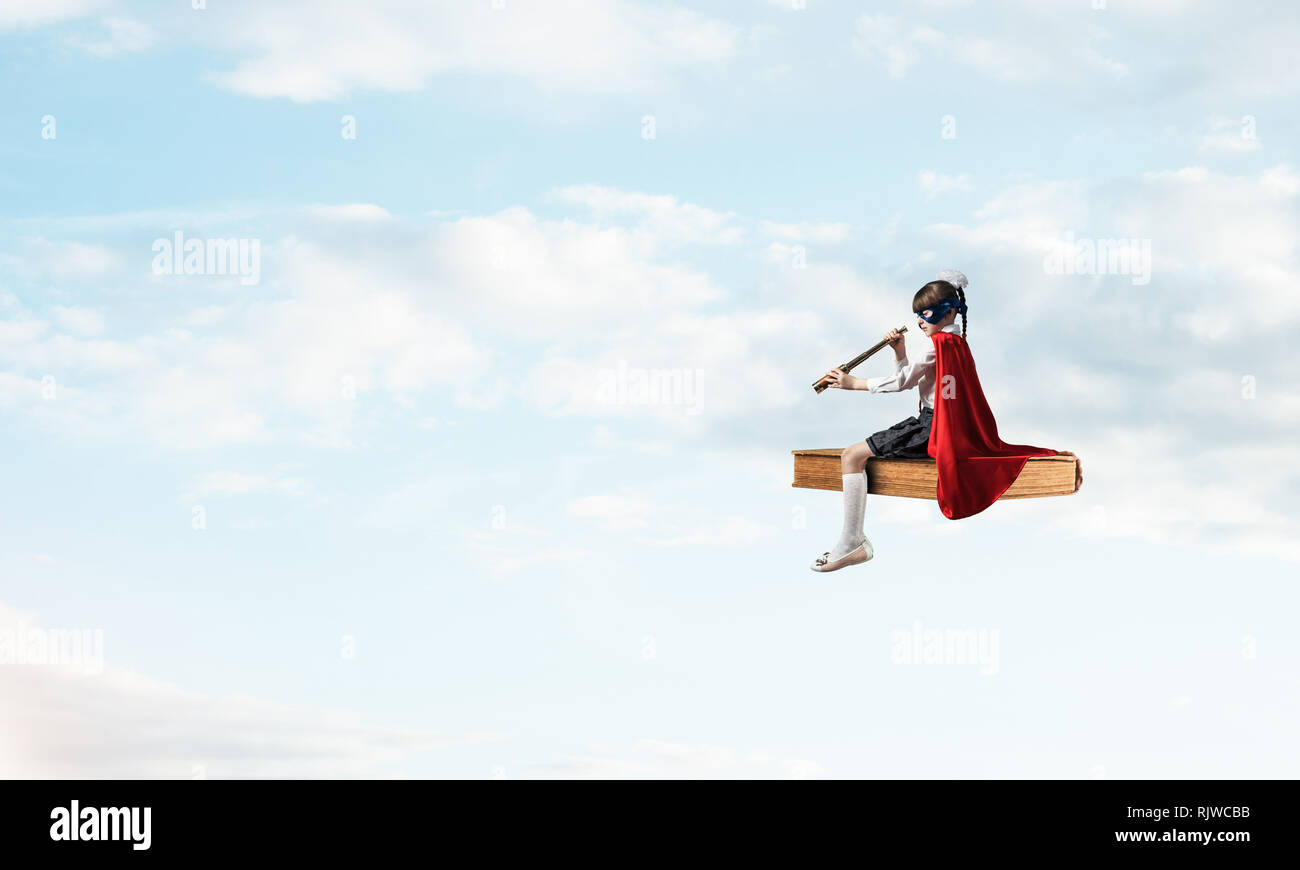 Girl power concept with cute kid guardian against cloudscape background ...