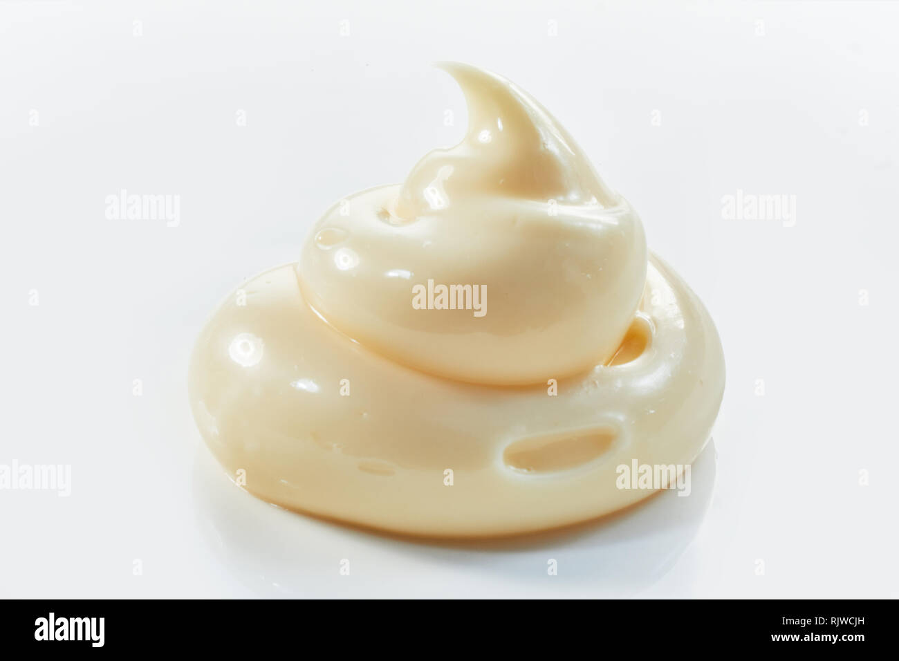 Food styling concept with twirled homemade spicy mayonnaise on a white ...