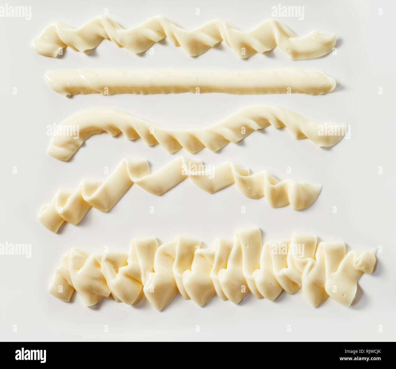 Assorted decorative drizzled lines of mayonnaise in waves and zigzags ...