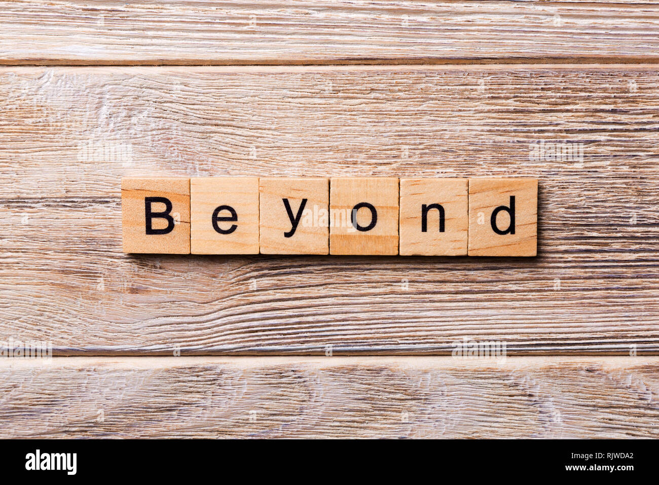 BEYOND word written on wood block. BEYOND text on wooden table for your ...