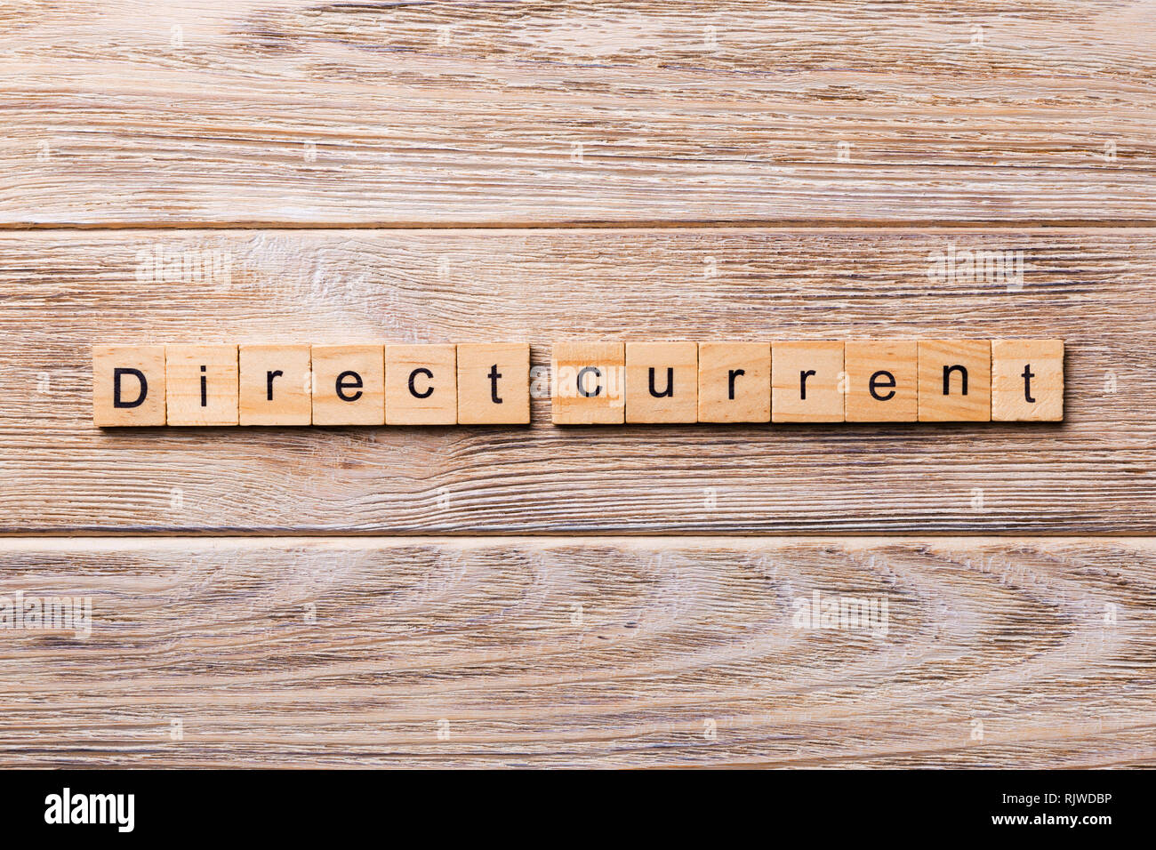 direct current word written on wood block. direct current text on ...
