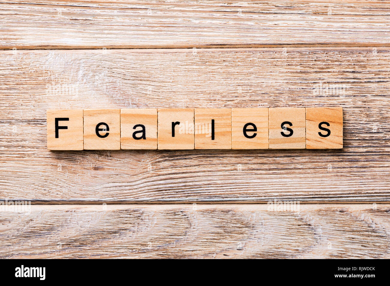 Fearless word written on wood block. Fearless text on wooden table for ...