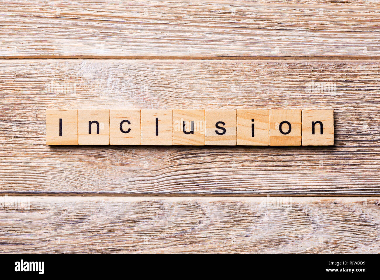 Inclusion word written on wood block. Inclusion text on wooden table ...