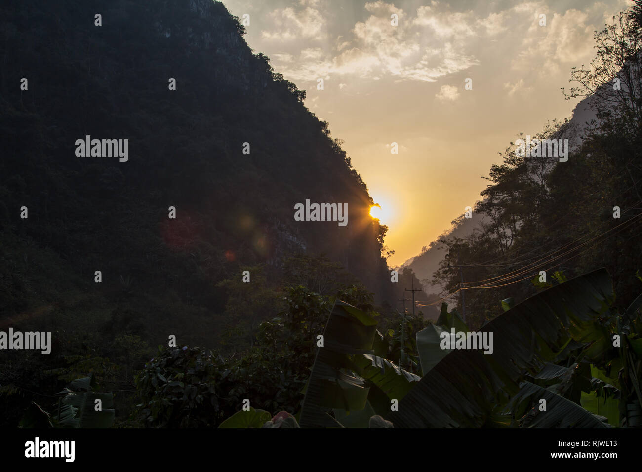 The sun setting in a remote jungle valley of the people's republic Laos ...