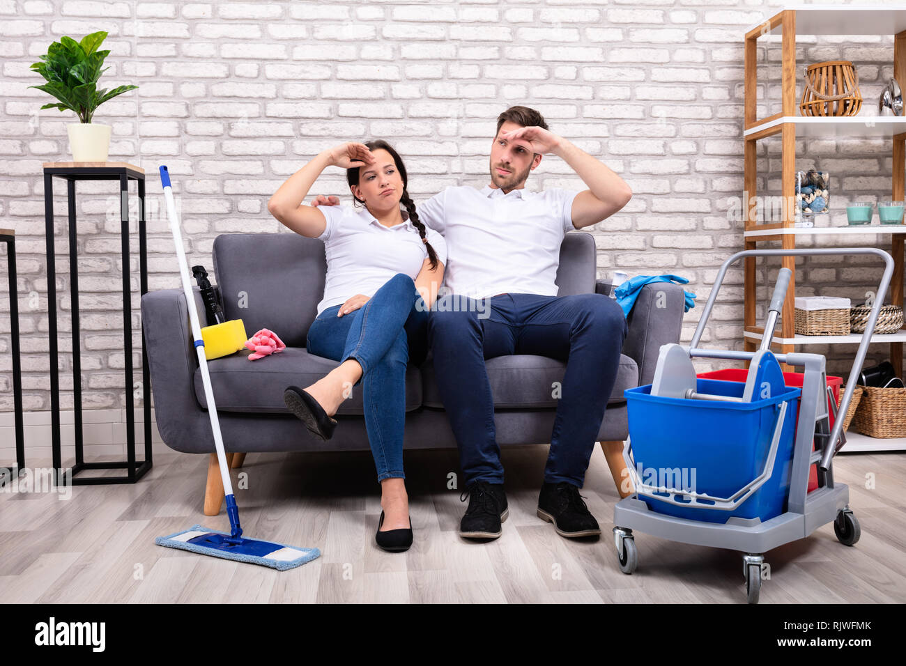Portrait Of Young Tired Couple Sitting On Sofa At Home Stock Photo - Alamy