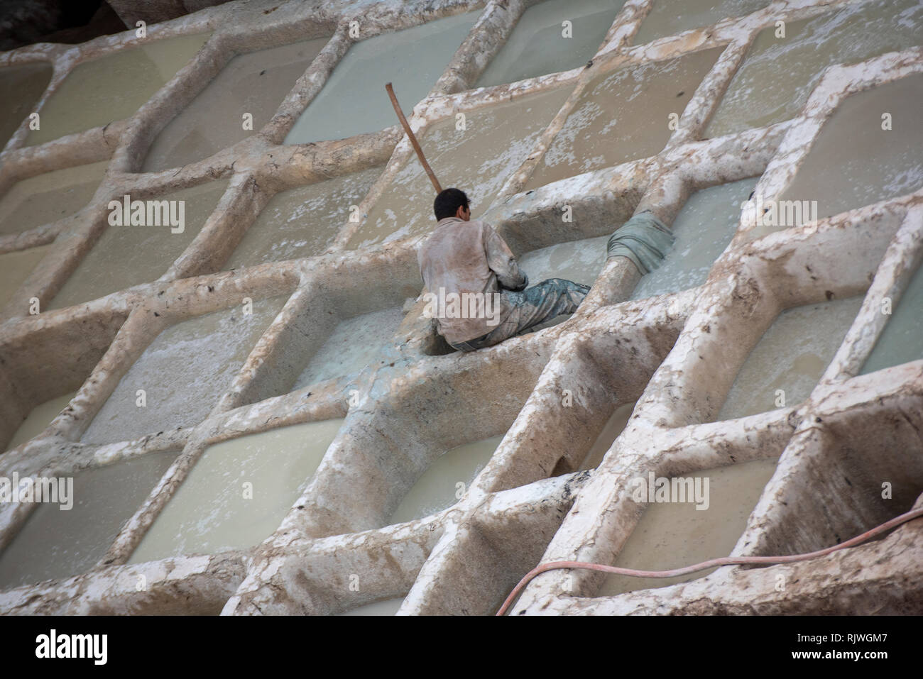Mаn working as a tanner in Old tanks at leather tanneries with color ...
