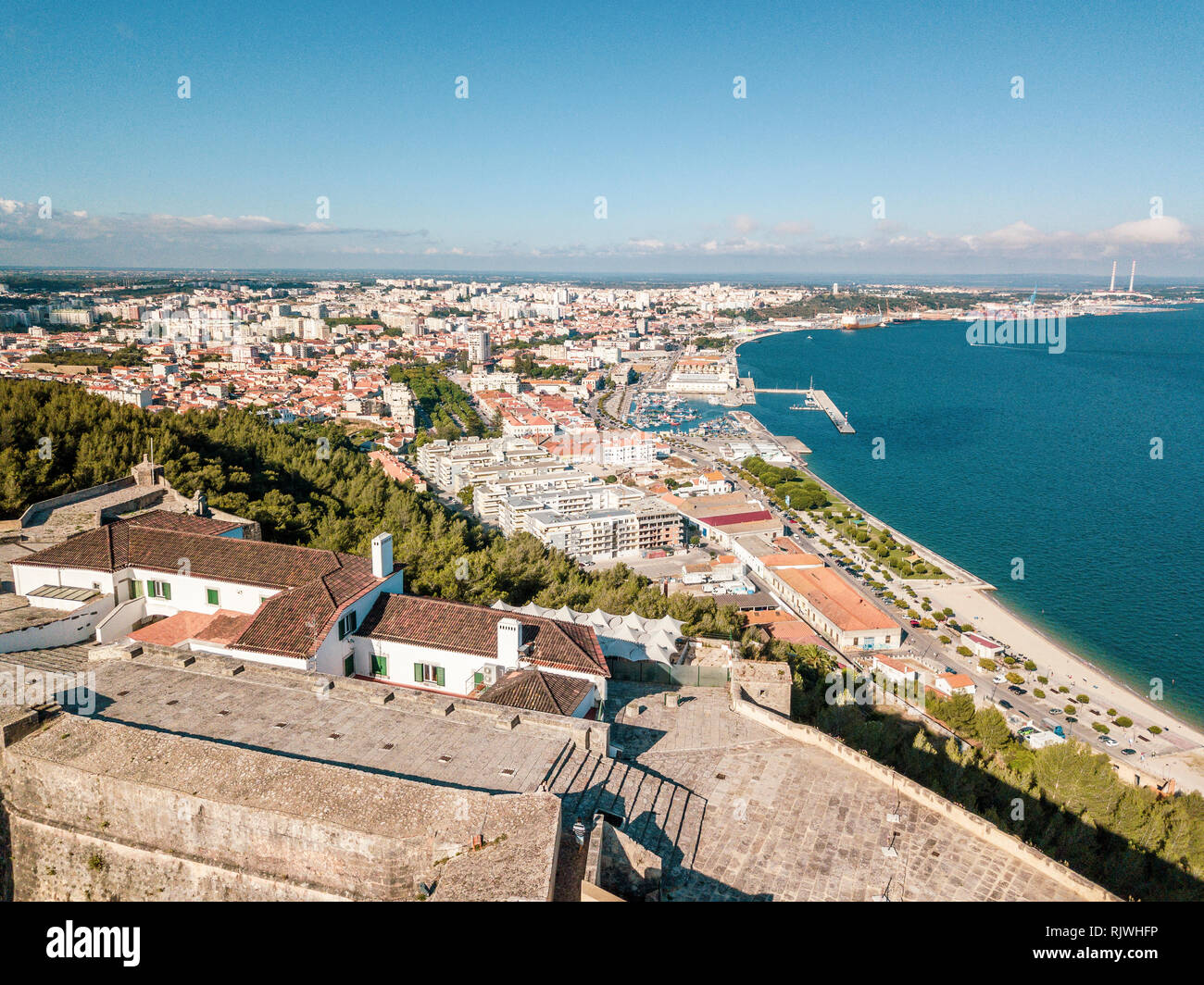 Aerial view of Setubal with forestry hills and fortress in the ...