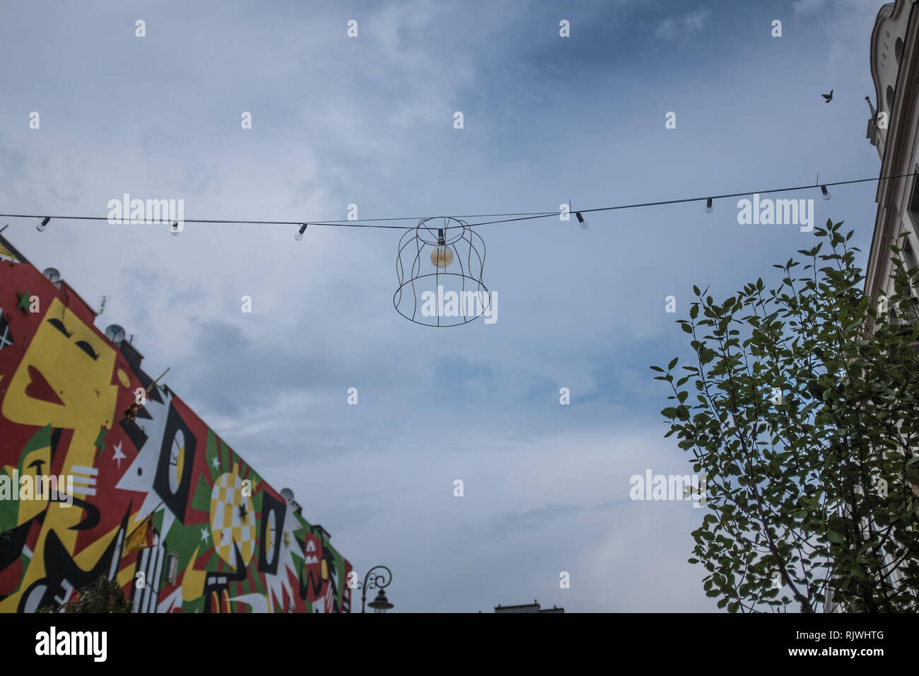 festive lighting across a street with a graffiti wall Stock Photo - Alamy