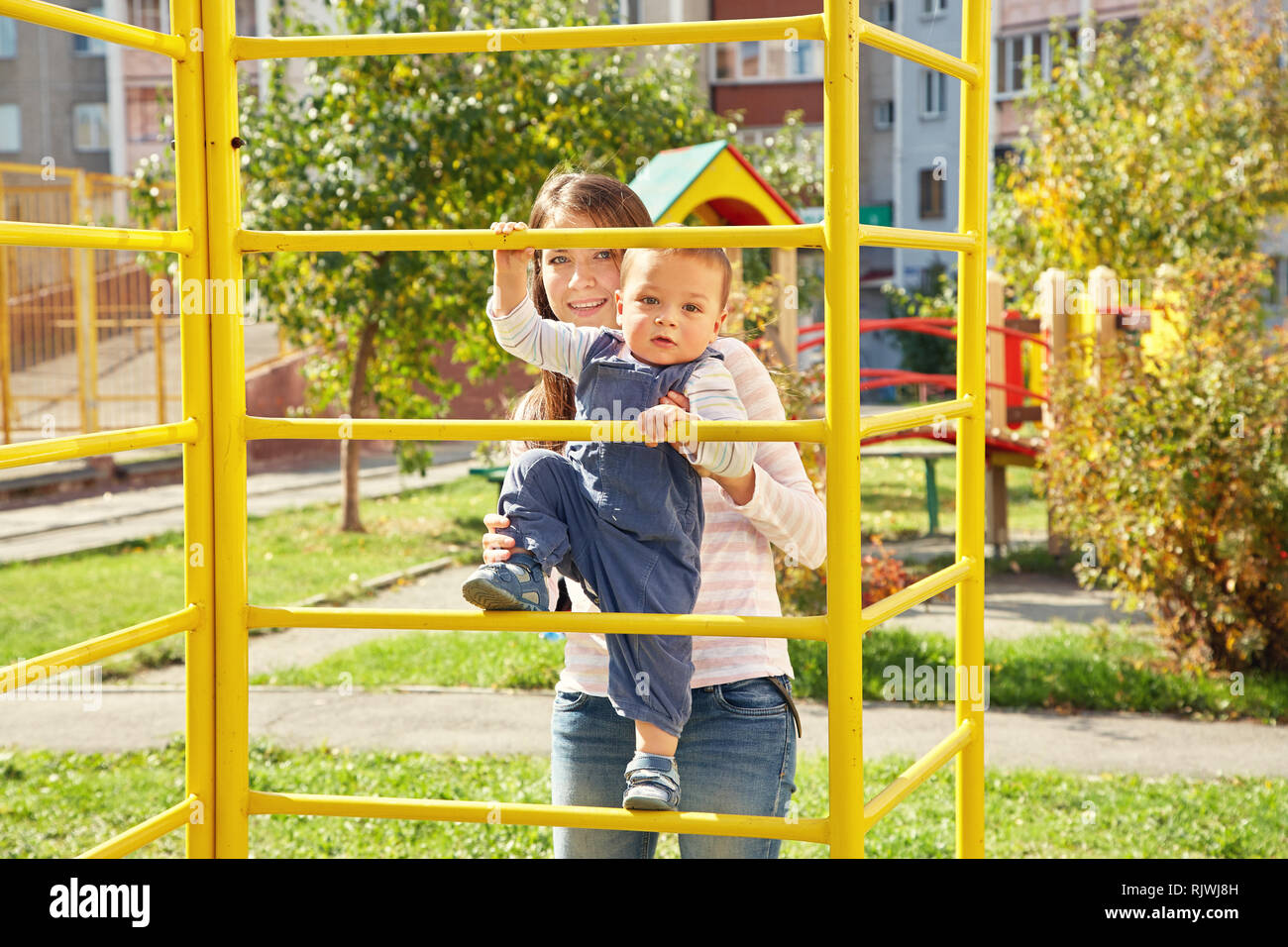 young mother playing with her baby on the playground. Mom and son Stock ...