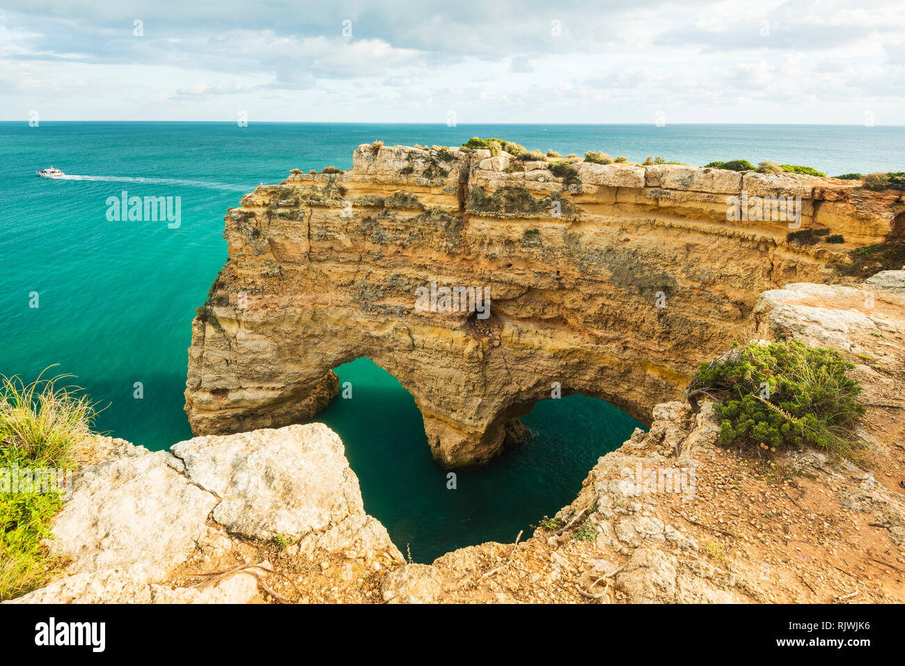 Natural arches underneath rugged cliffs, Praia da Marinha, Algarve ...