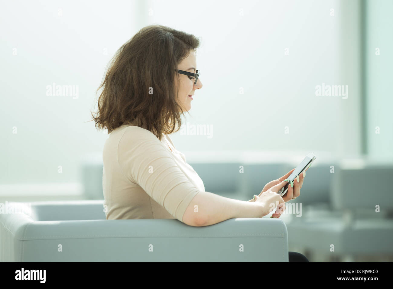 modern business woman with smartphone sitting in office reception Stock ...