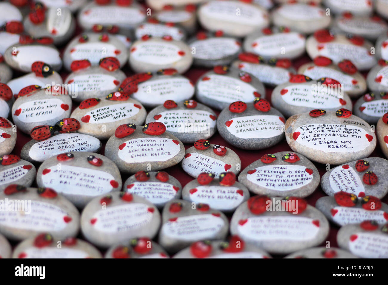 Round pebbles message stones, handmade souvenirs on Greek island Stock ...