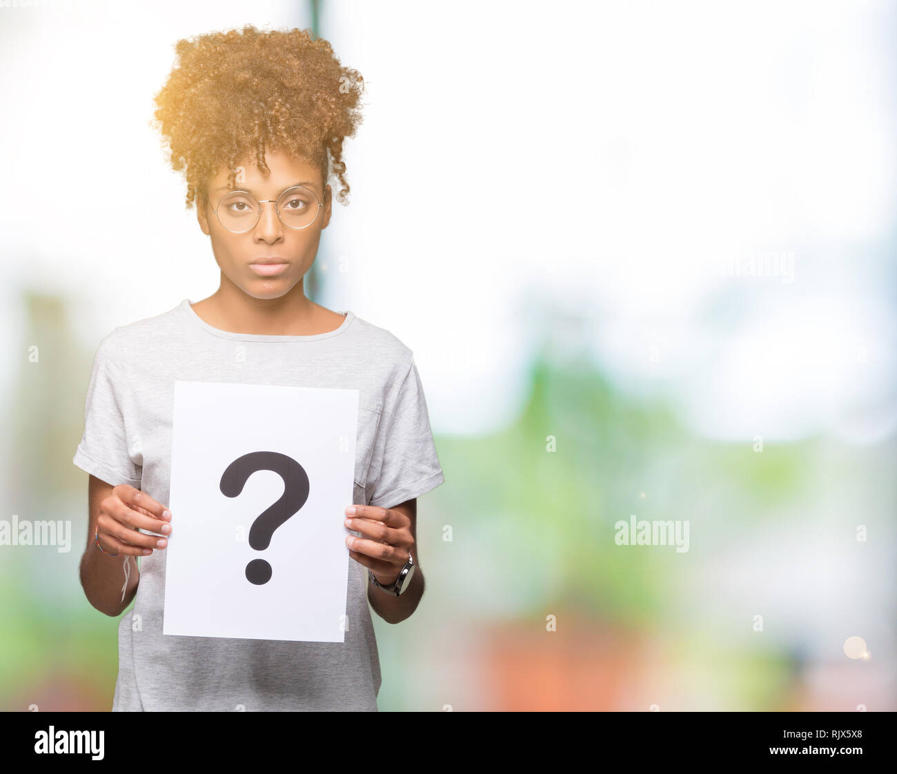 Young african american woman holding paper with question mark over ...