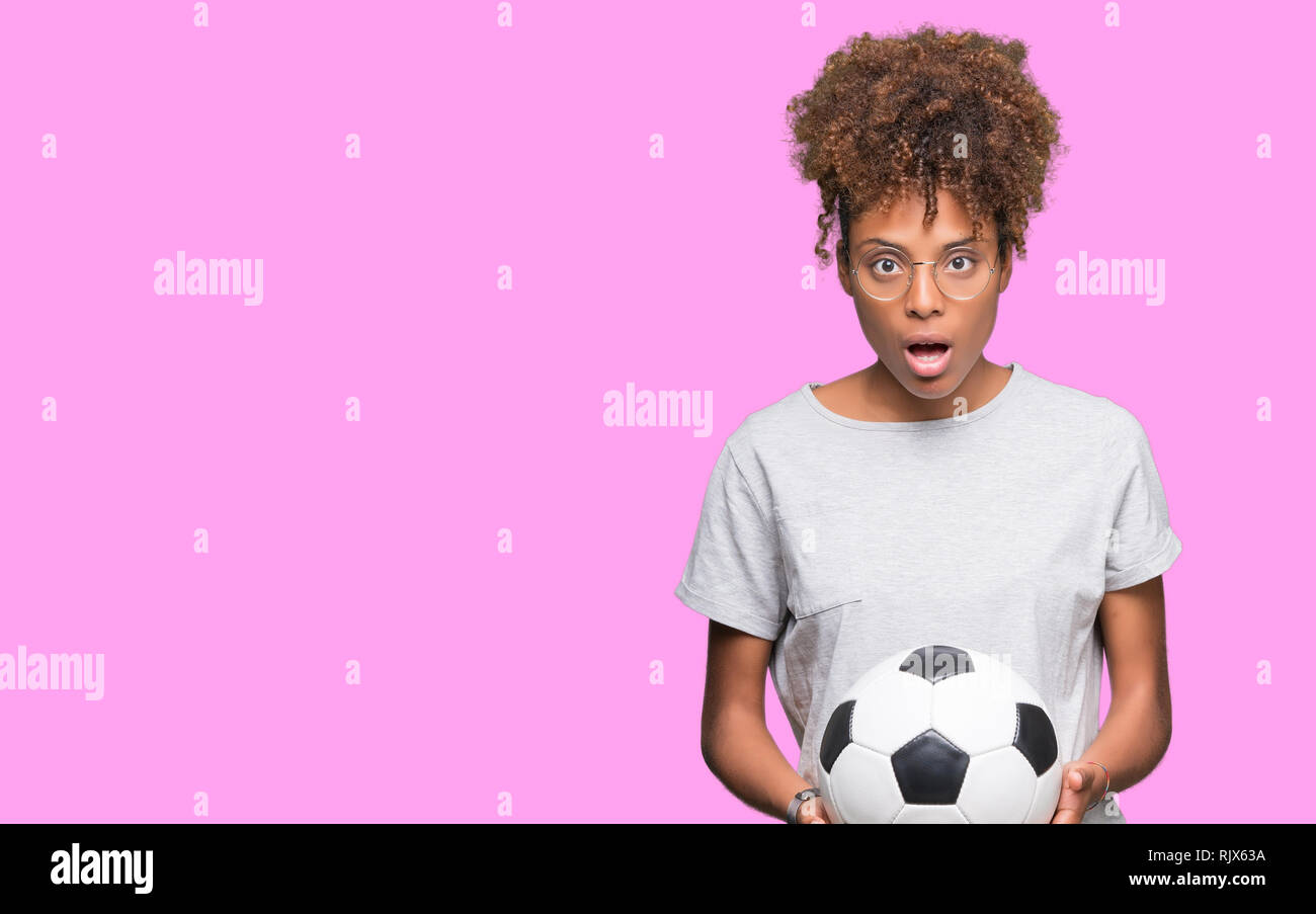Young african american woman holding soccer football ball over isolated ...