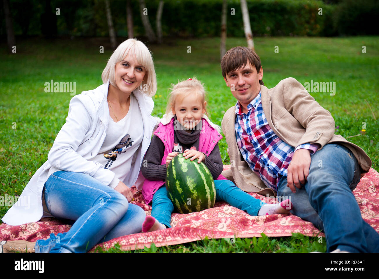 Family is eating a watermelon together in the park Stock Photo - Alamy