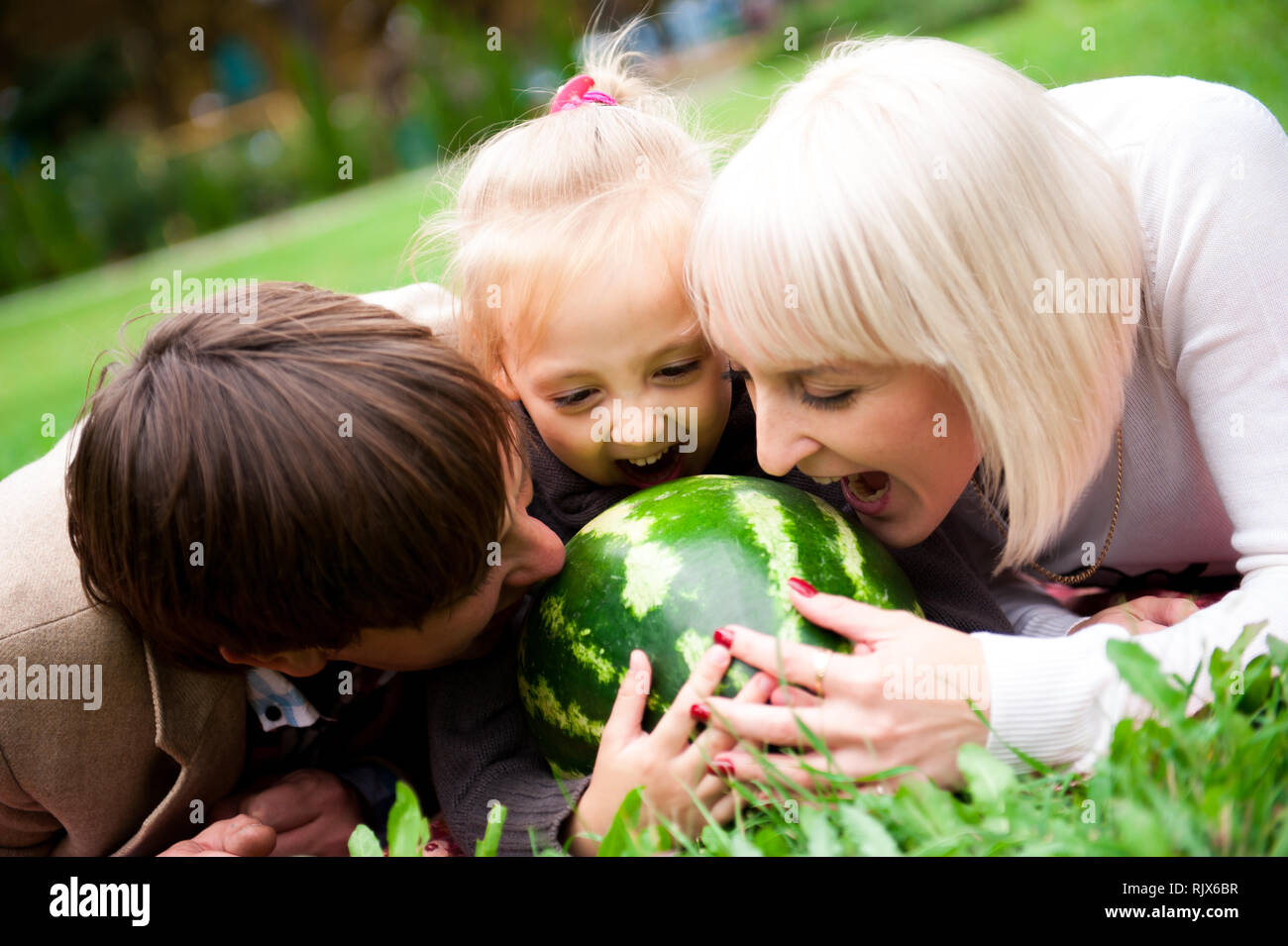 Family is eating a watermelon together in the park Stock Photo - Alamy