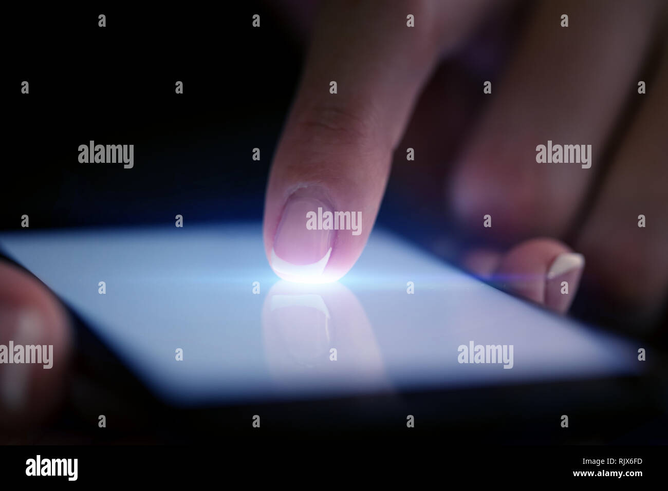 Finger touching phone with dark background with copyspace Stock Photo ...