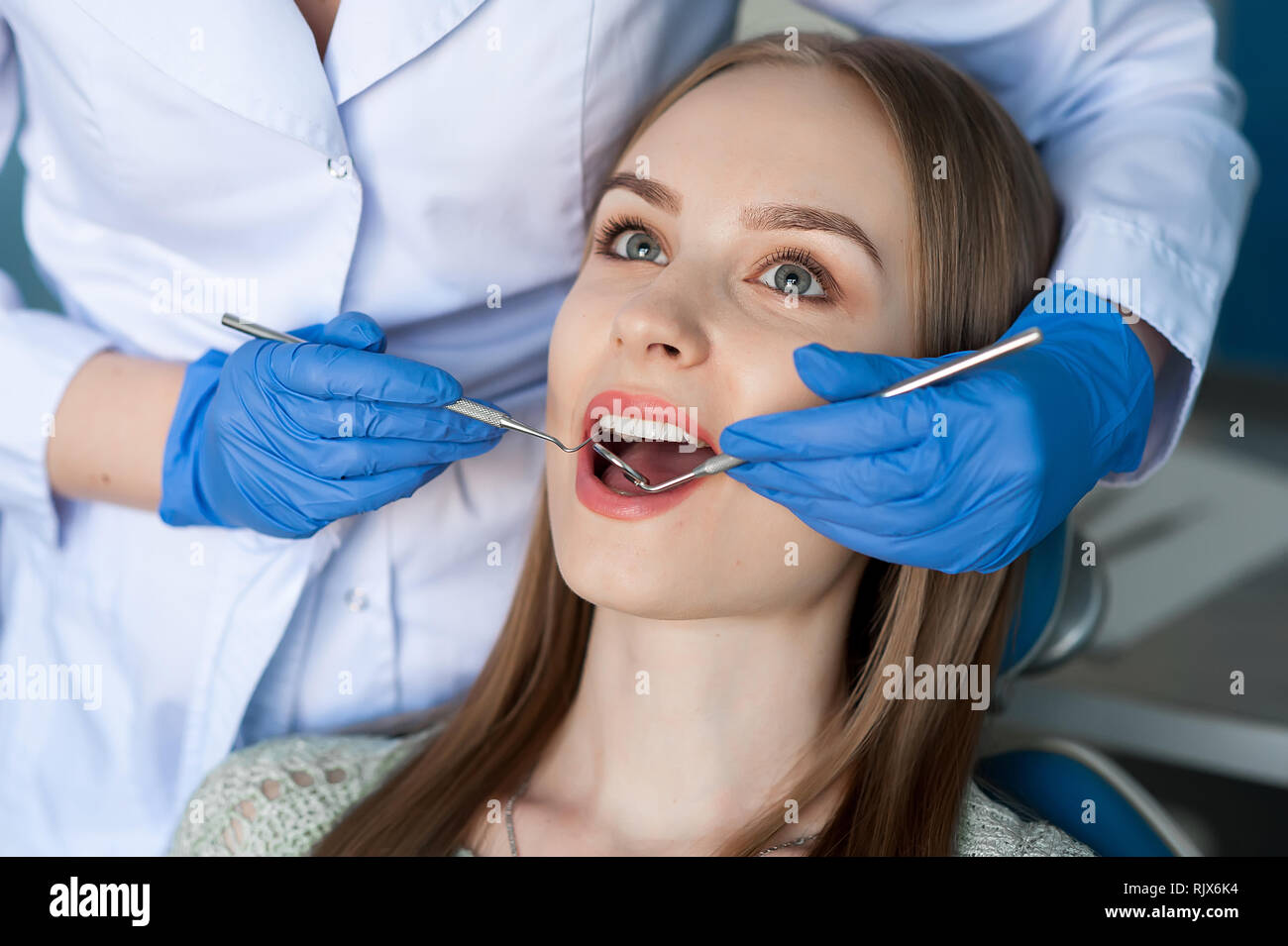 Dentist examining a patient's teeth in the dentist Stock Photo - Alamy