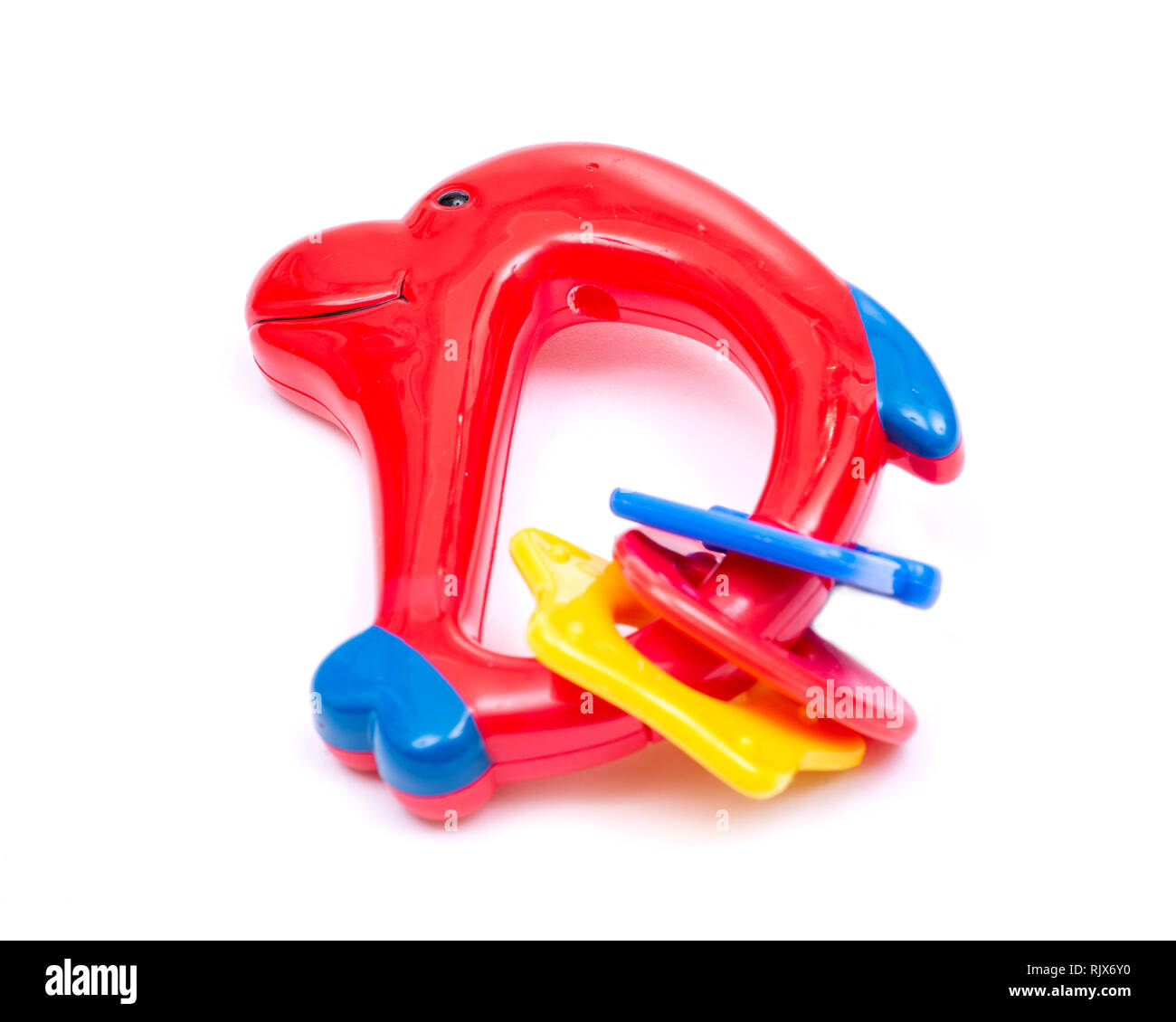 Dolphin shaped red rattle toy for a newborn baby isolated on white ...