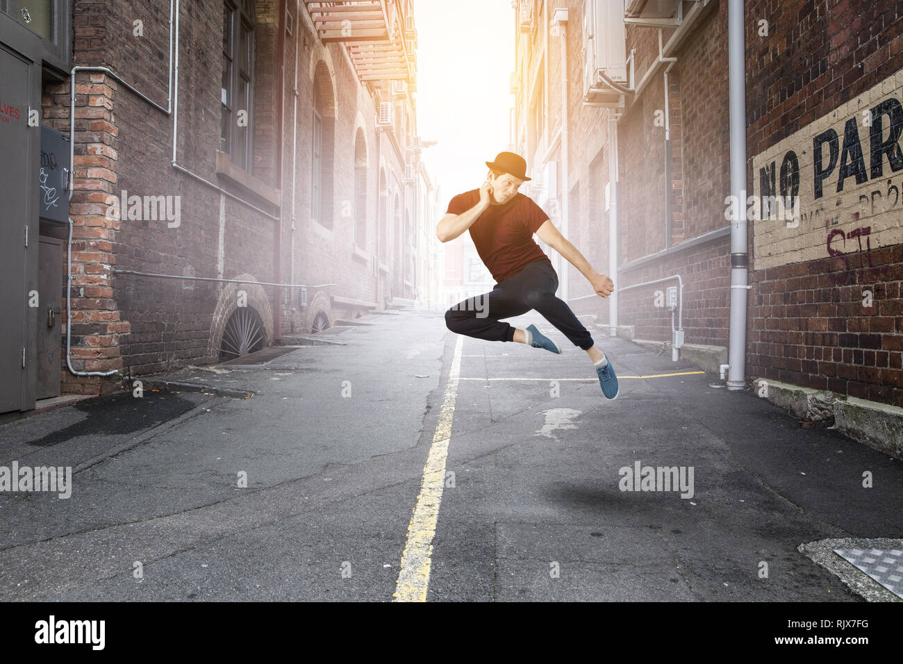 Young male professional dancer in hat jumping high. Mixed media Stock ...