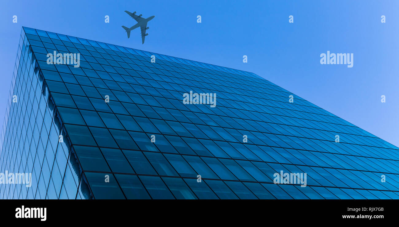 Bottom angle view of airplane in sky over city buildings Stock Photo ...