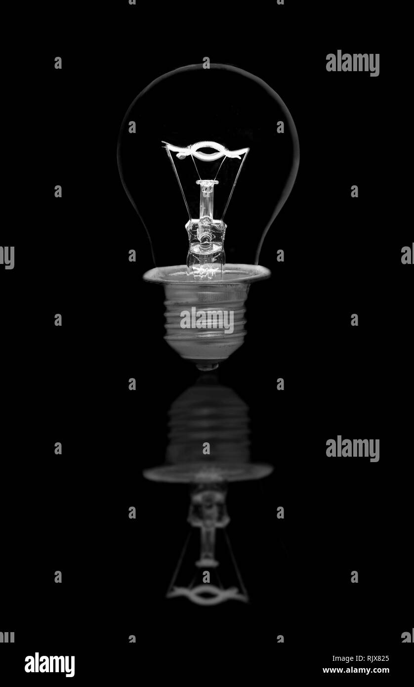 Incandescent light bulb on black background Stock Photo - Alamy