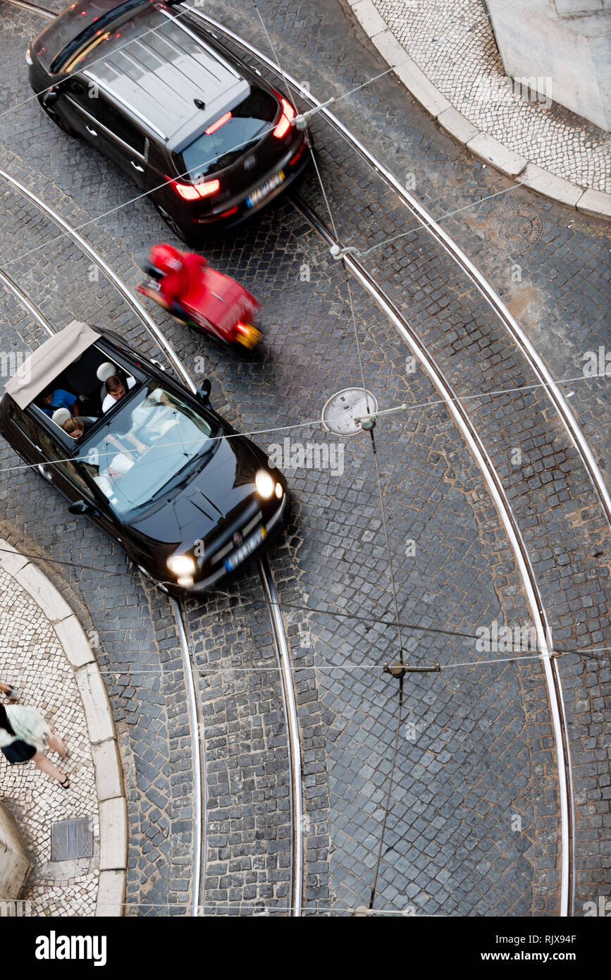 Lisbon cobblestone curved street aerial with tram tracks, dense traffic ...