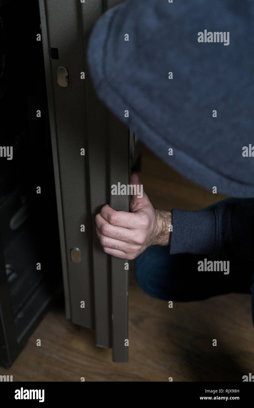 Hooded criminal thief stealing a safe Stock Photo - Alamy