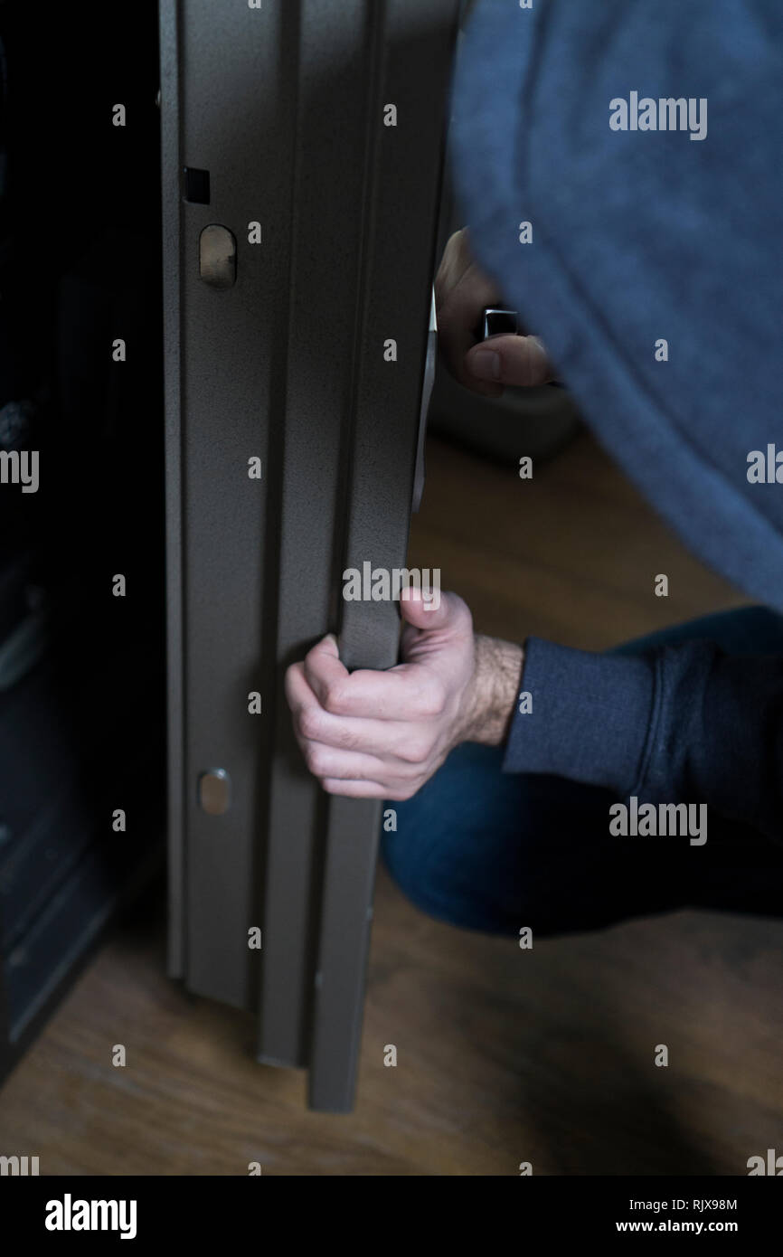 Hooded criminal thief stealing a safe Stock Photo - Alamy
