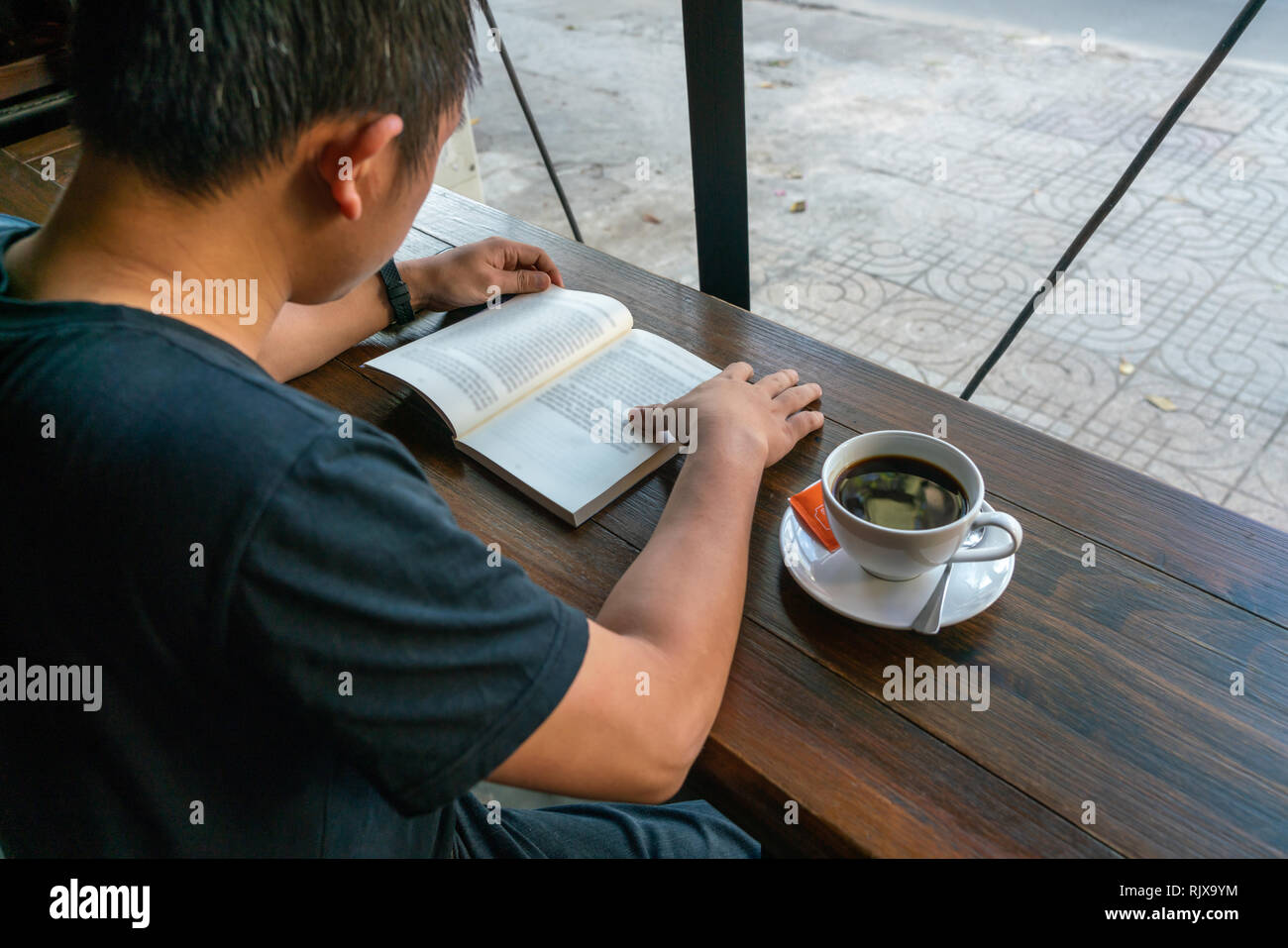 Student reading book and drinking coffee Stock Photo - Alamy