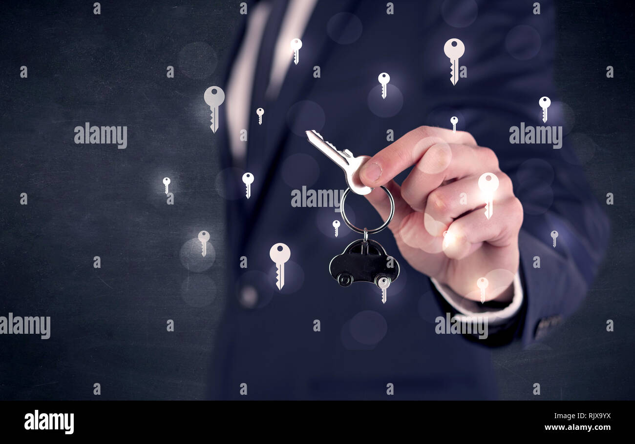Businessman in suit holding keys with keys graphics around and dark ...