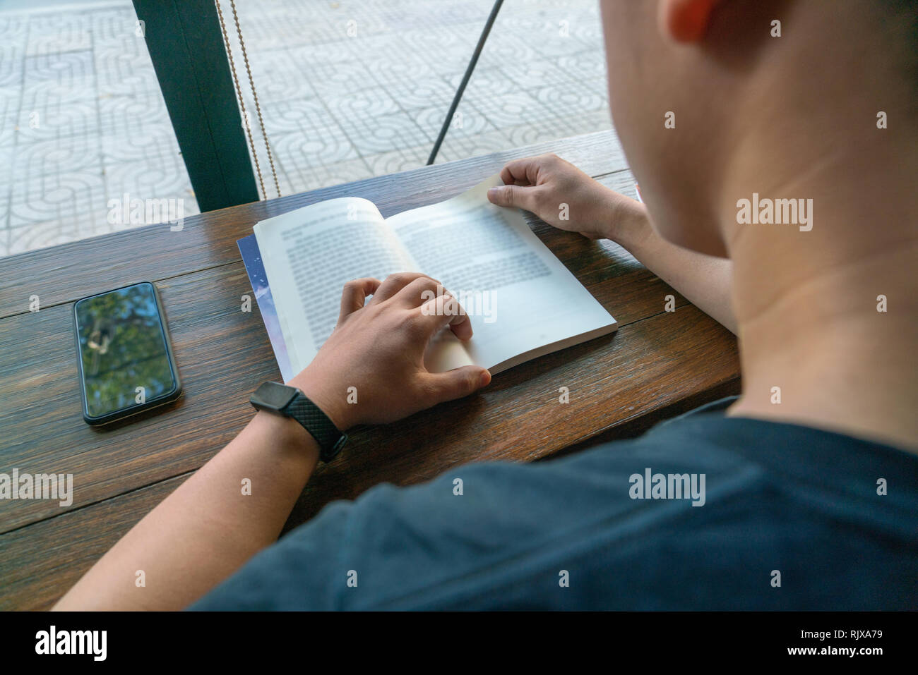 Rear view of young man read a book Stock Photo - Alamy