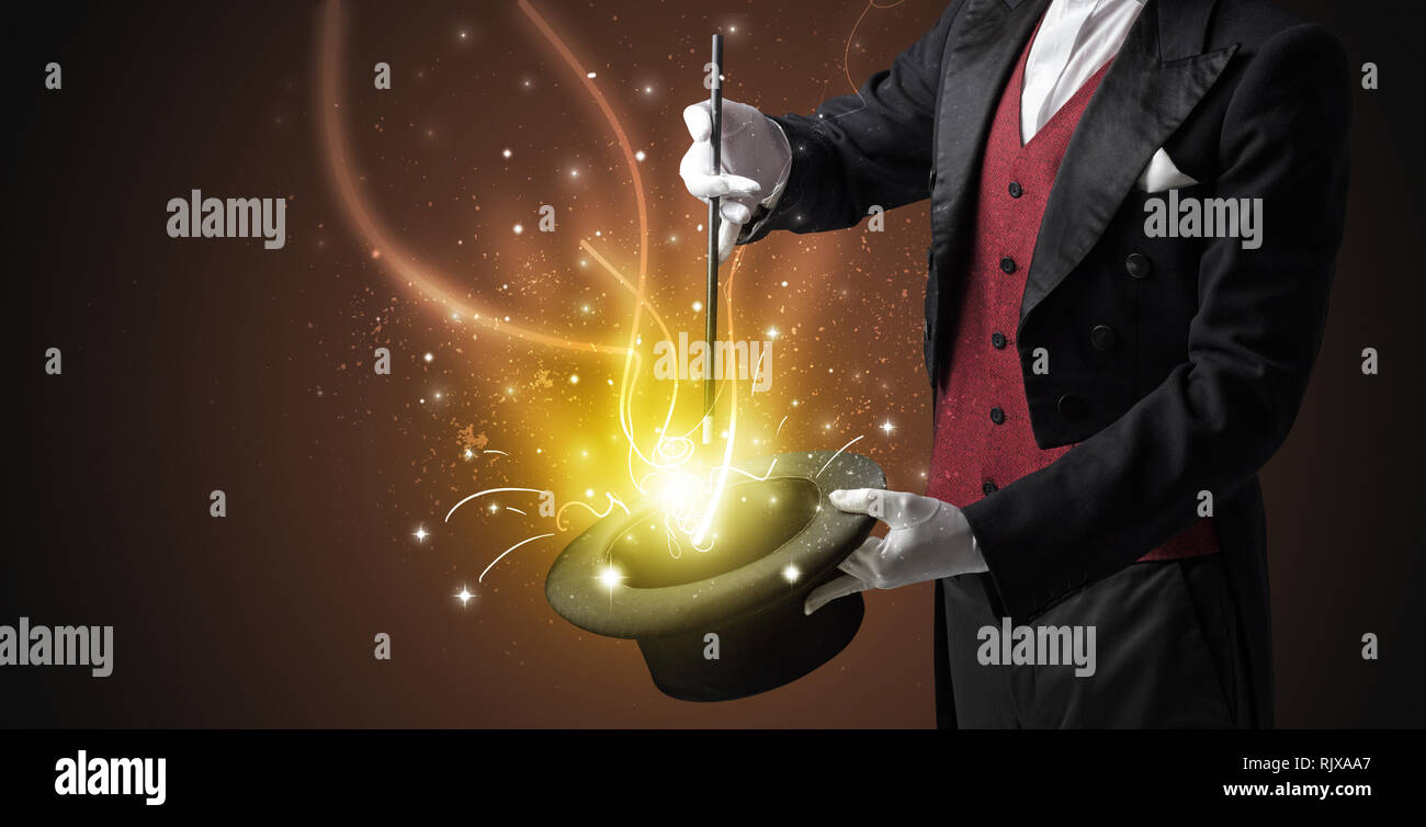 Magician hand conjure with wand light from a black cylinder Stock Photo ...