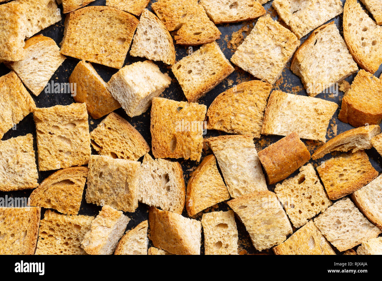 Crispy croutons on baking pan. Many croutons useful as food background ...