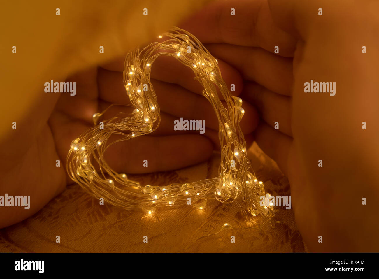 Love symbol, heat shaped lights on golden colour background Stock Photo ...