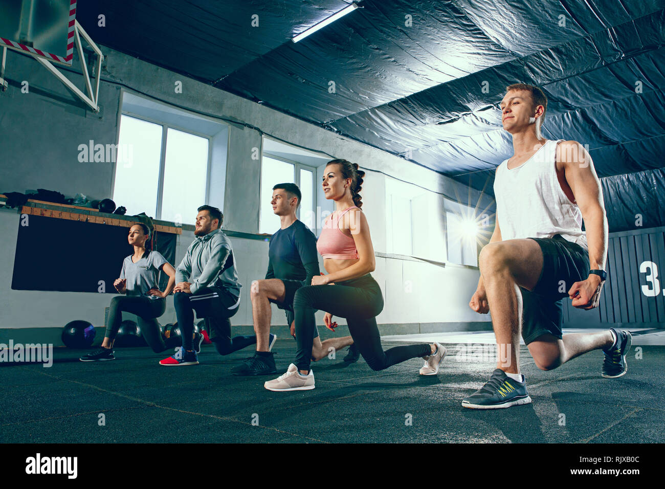 Shot of young men and women at the gym. Functional fitness workout. The ...