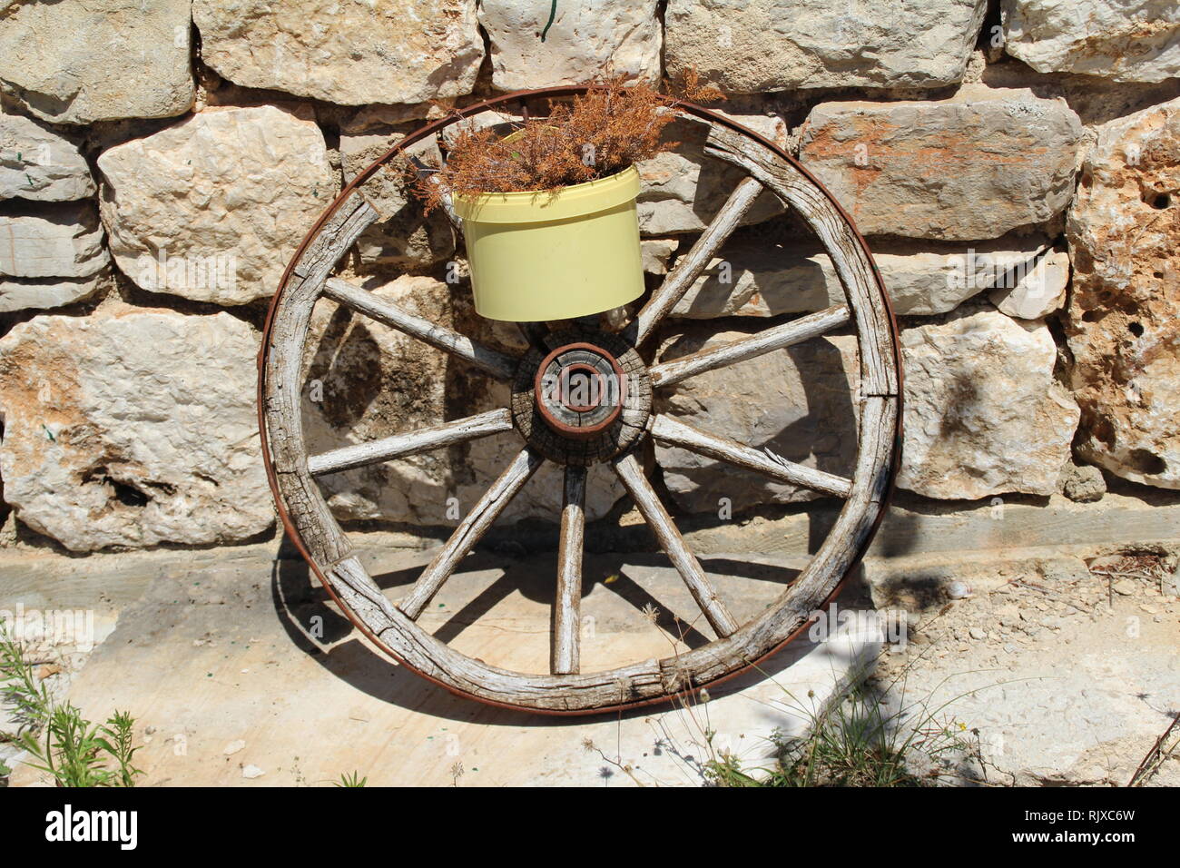 Old wagon wheel standing at the wall Stock Photo - Alamy