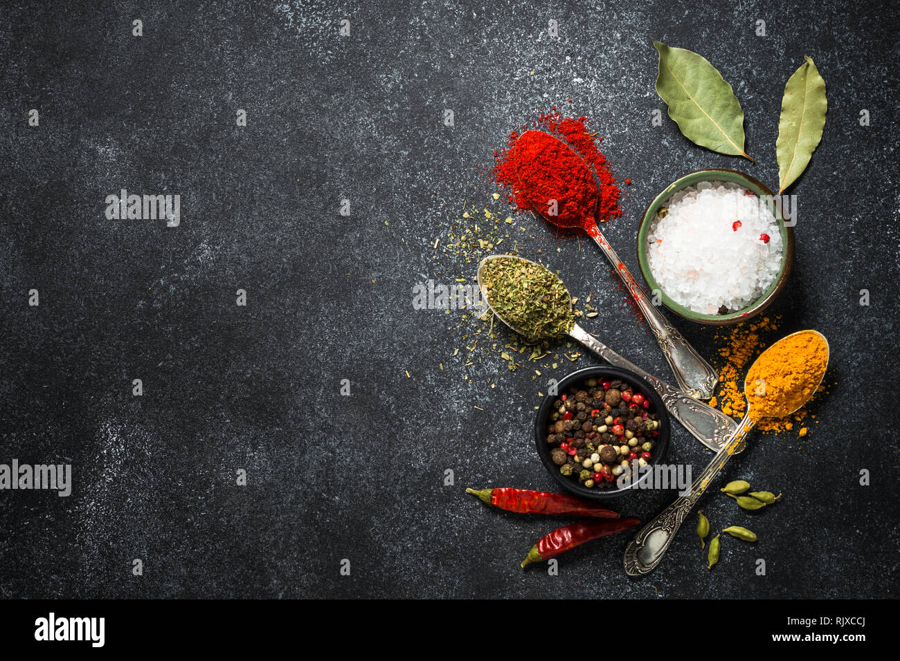 Spices, sea salt and pepper on black stone background Stock Photo - Alamy