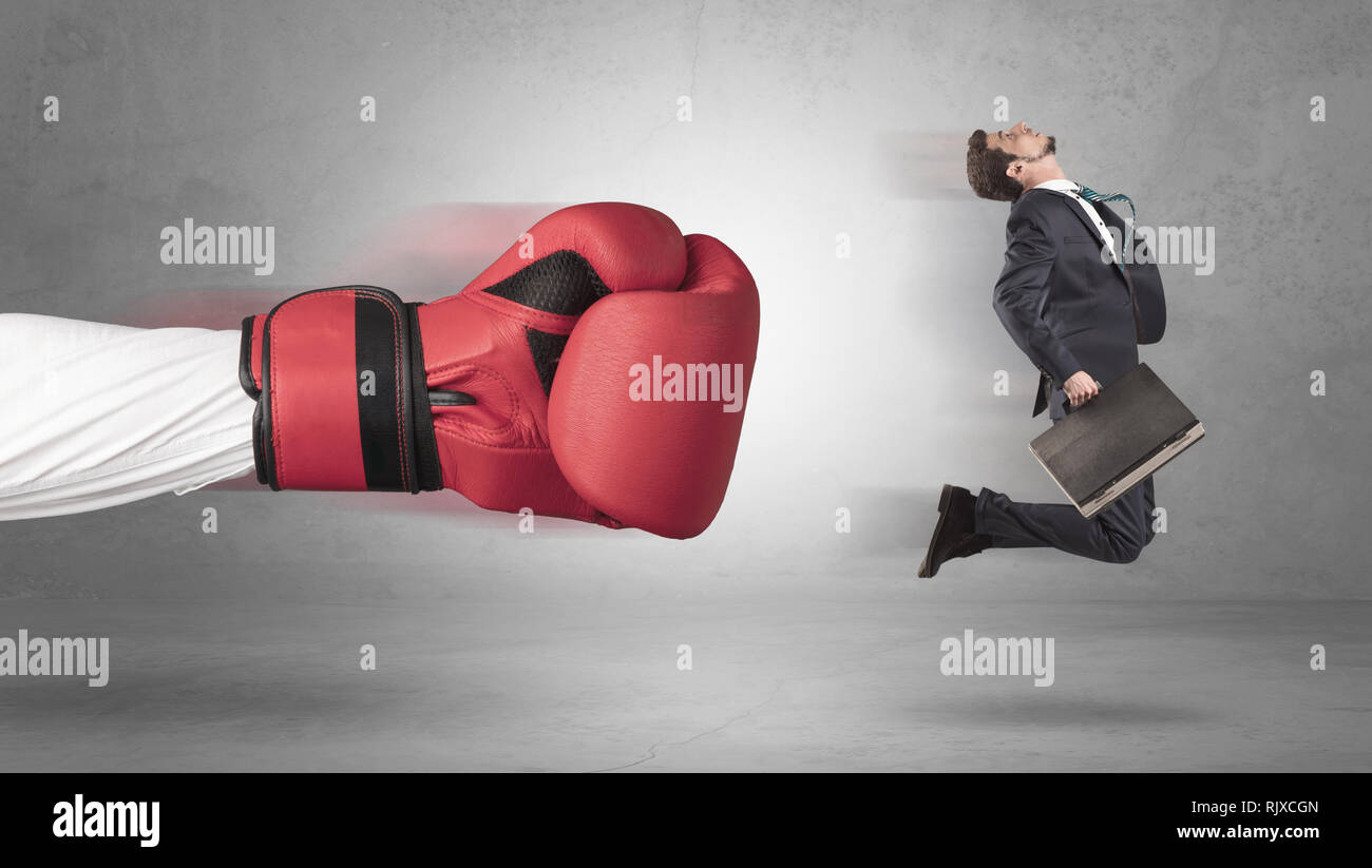 Businessman gets a hit from a giant hand with boxing gloves Stock Photo ...